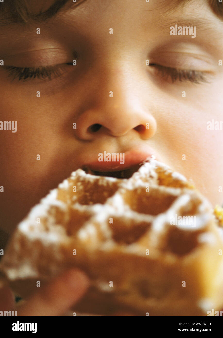 Child eating waffle, close-up Stock Photo - Alamy