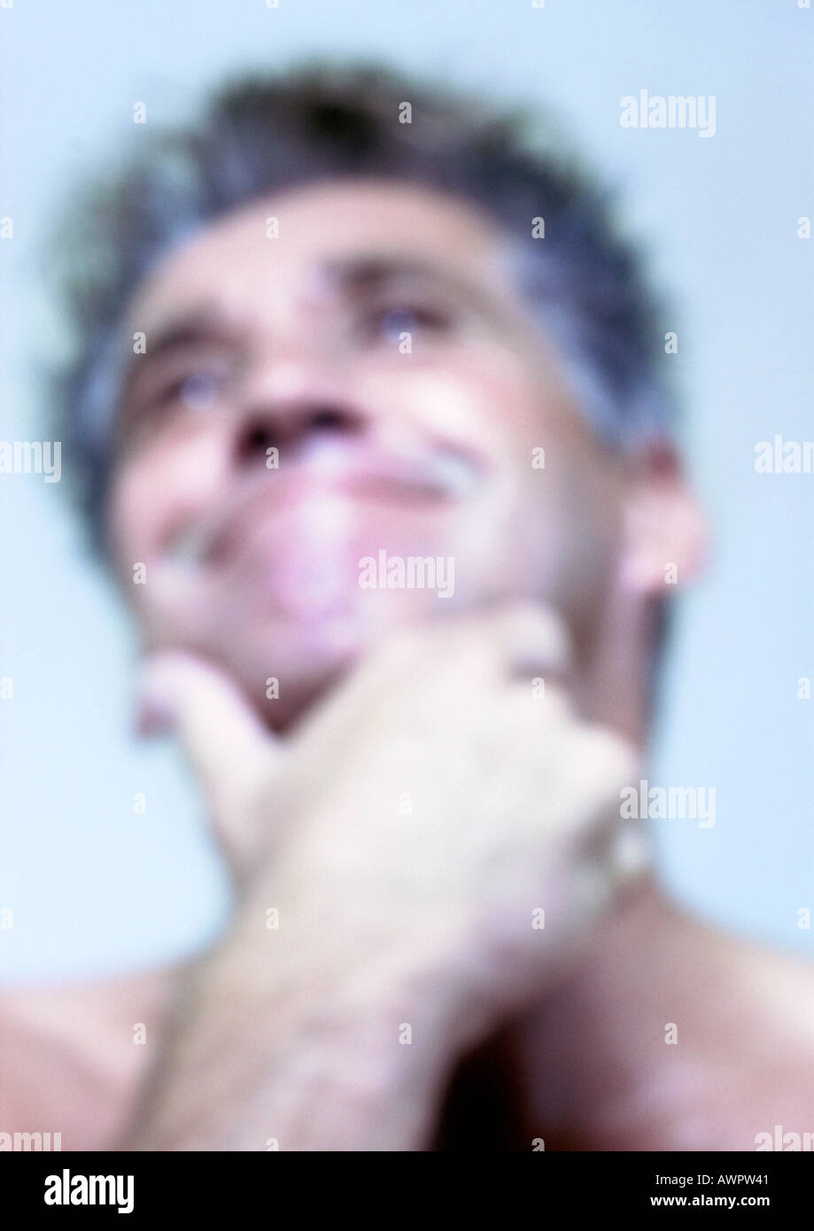 Mature man holding chin and smiling, close-up, portrait Stock Photo - Alamy