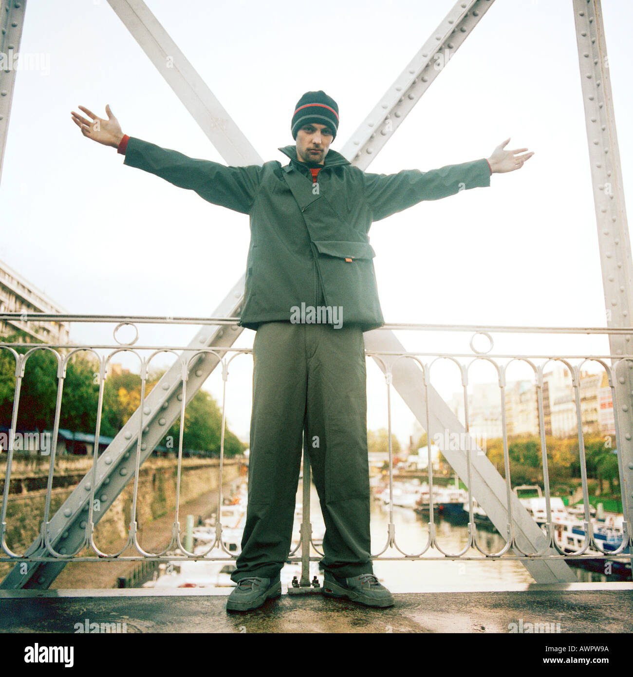 Man standing on bridge with arms stretched out Stock Photo - Alamy