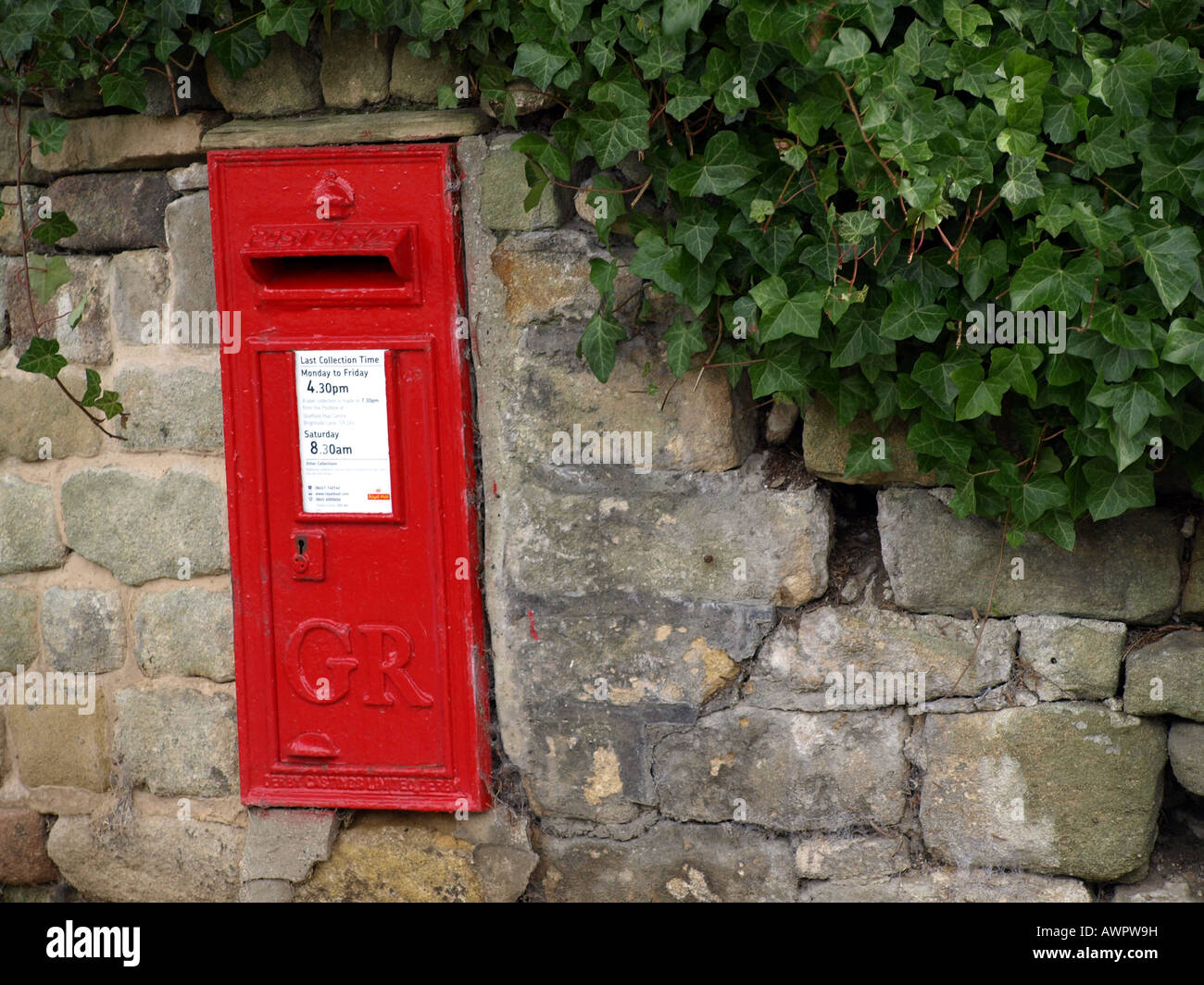 king George post box buried in stone wall with ivy Stock Photo - Alamy