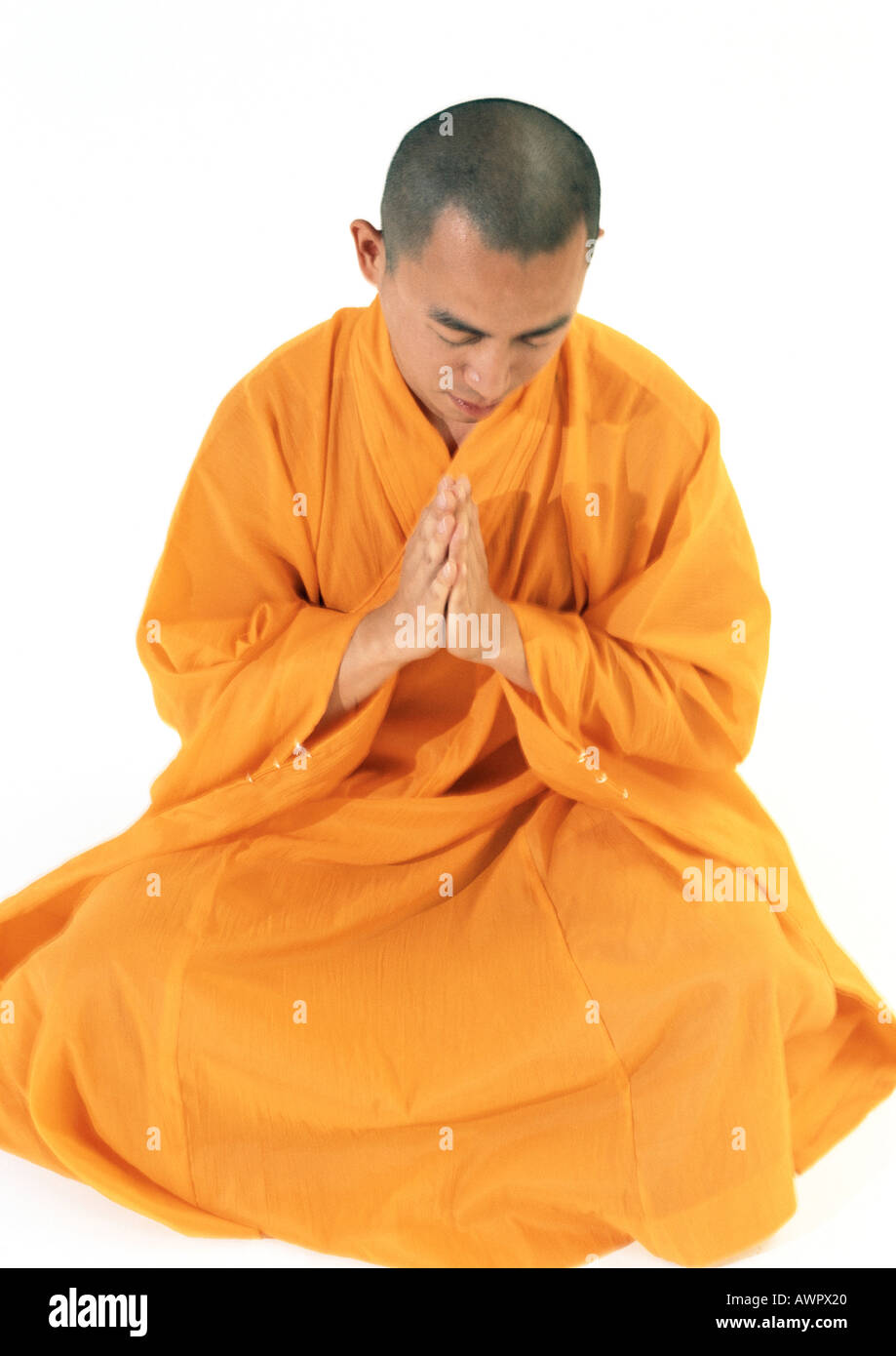 Buddhist monk sitting, meditating with hands together, high angle view ...