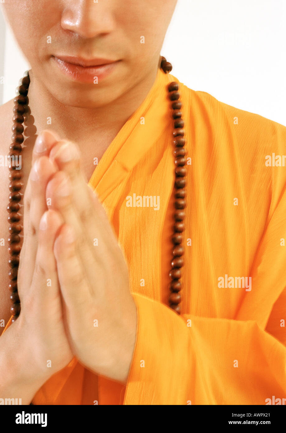 Buddhist monk meditating with hands together, close-up Stock Photo - Alamy