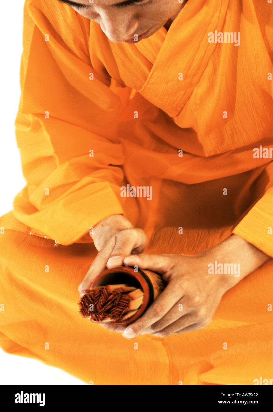 Buddhist monk meditating, holding devotional objects Stock Photo - Alamy