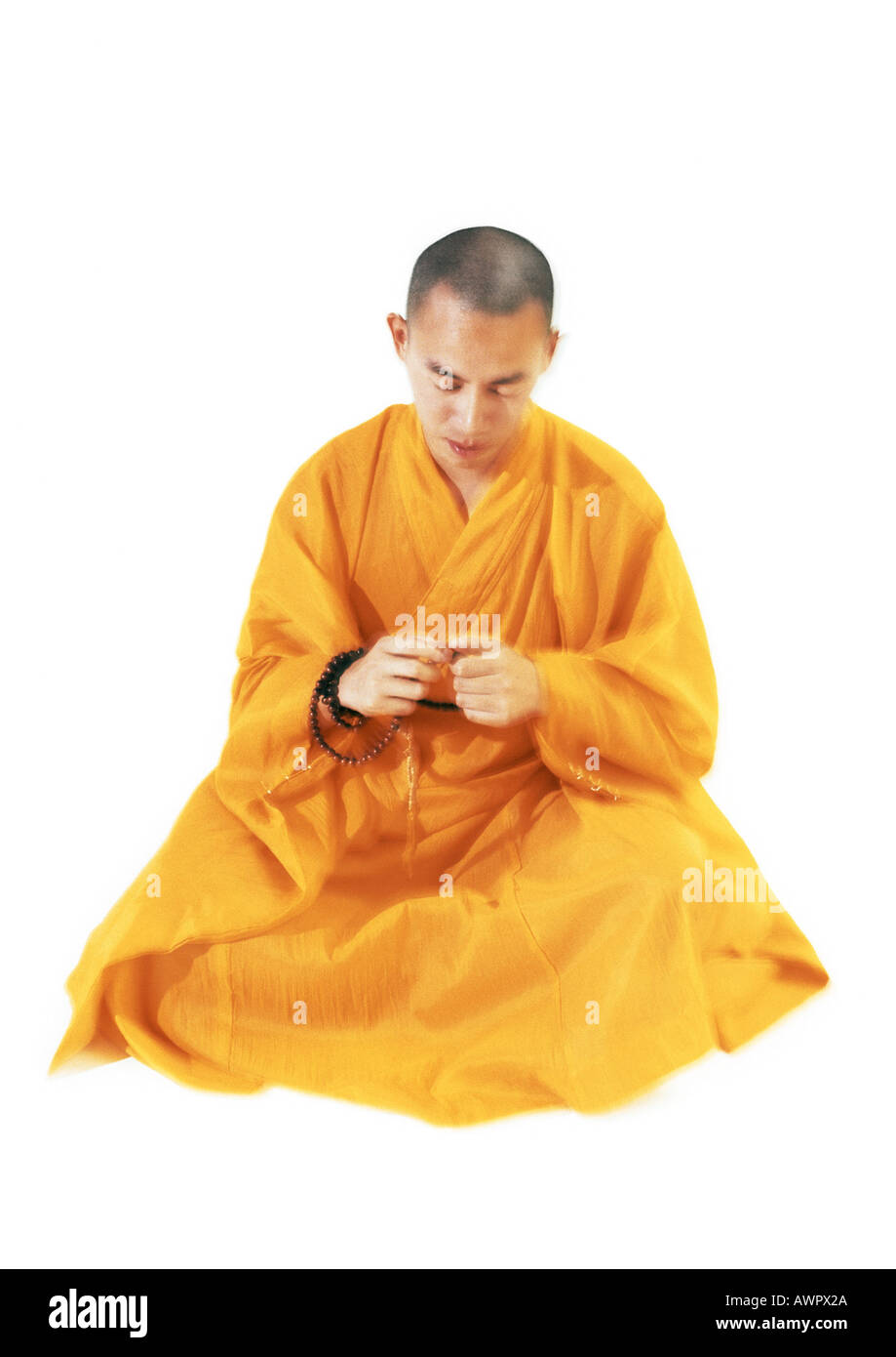 Buddhist monk sitting and meditating, holding prayer beads Stock Photo ...