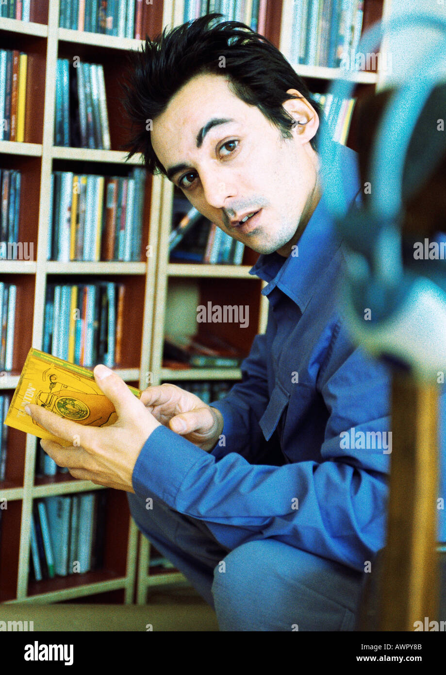 Young man in front of cd collection, looking into camera, portrait ...