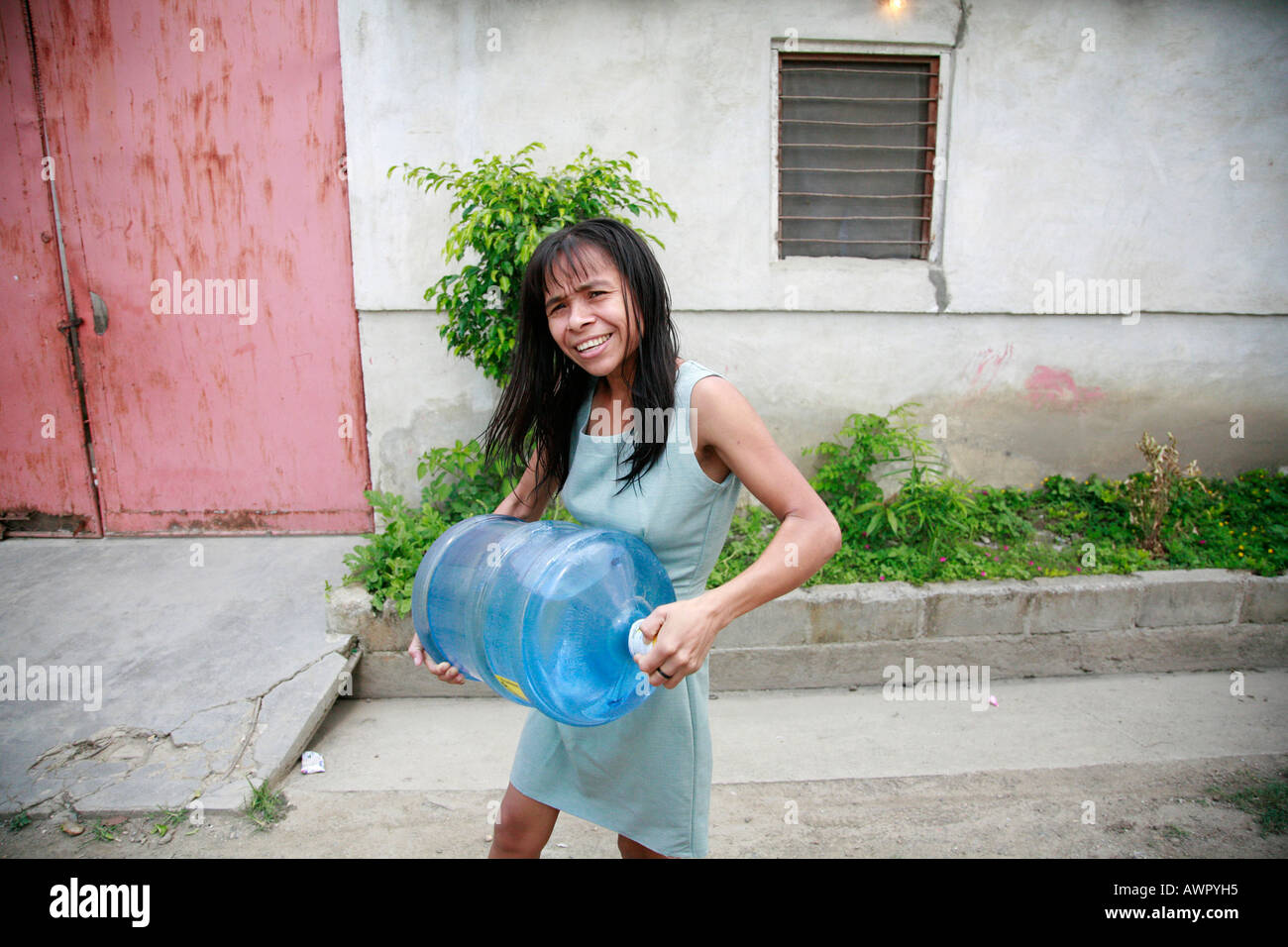 HONDURAS Woman carrying drinking water The slum barrio of Chamelecon ...