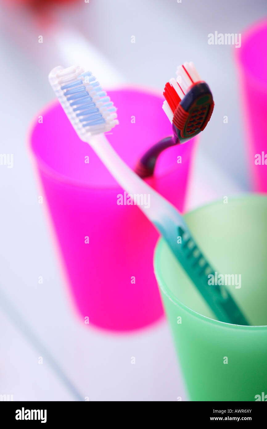 Two toothbrushes in colored toothbrush tumblers Stock Photo - Alamy