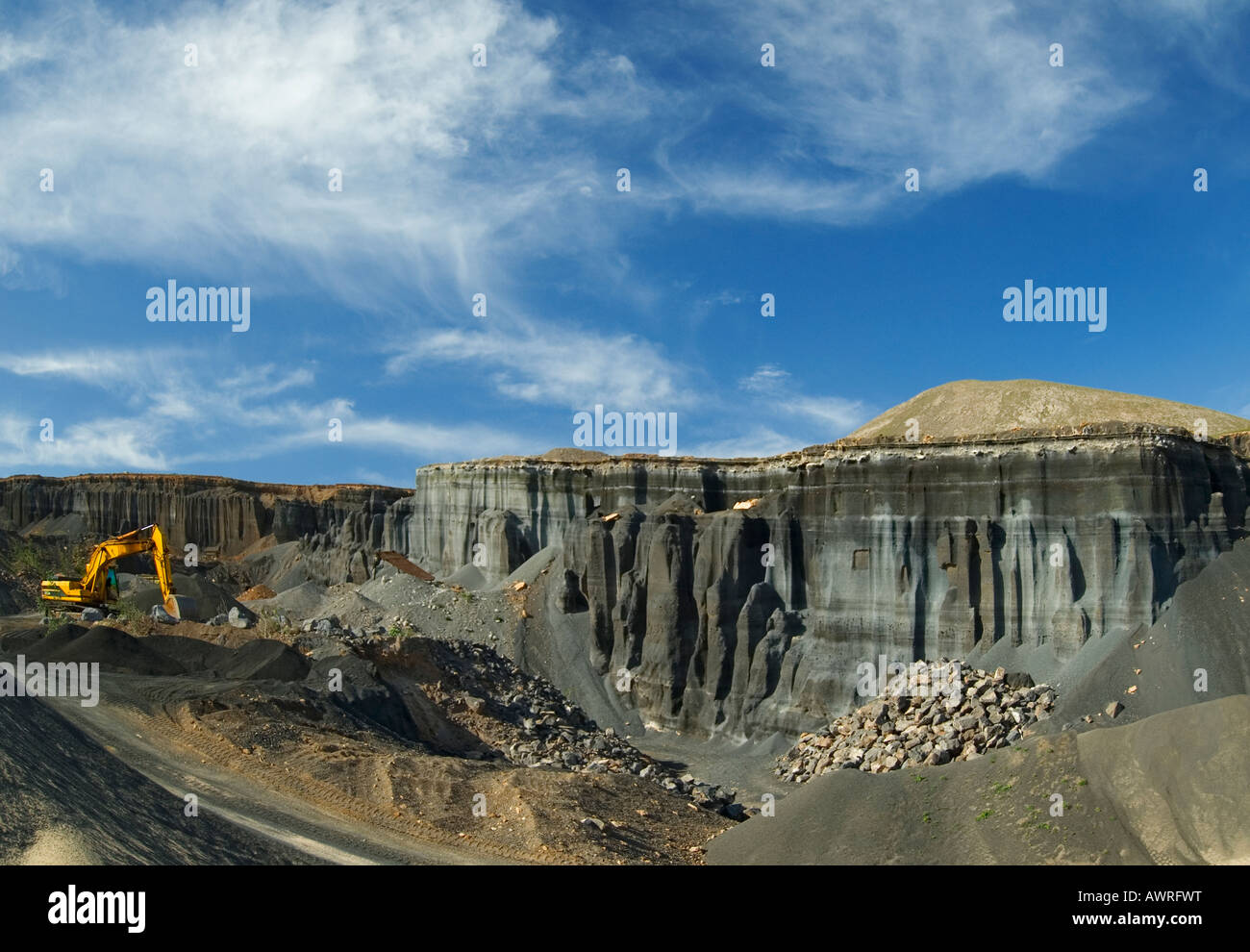 Mechanical digger mining volcanic picon gravel from ash which is an ...