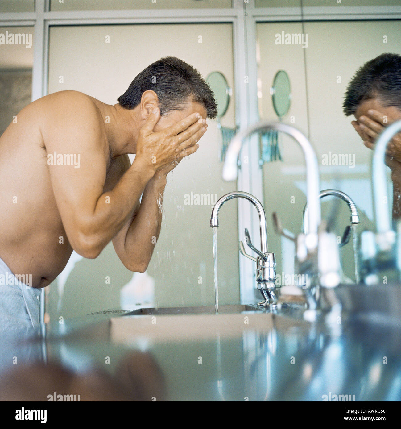 Man rinsing face, side view Stock Photo - Alamy