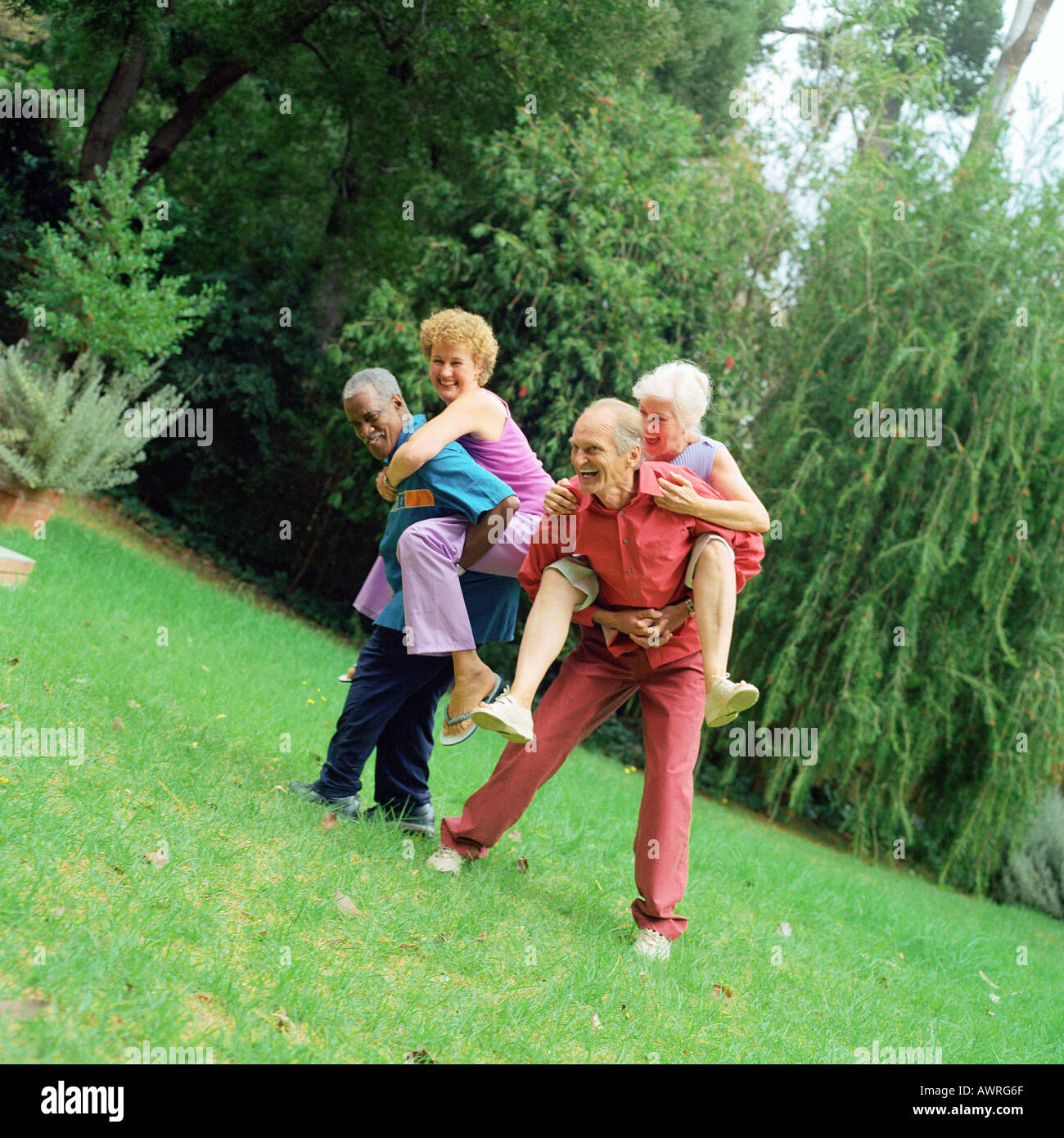 Two mature men giving women piggyback rides, outdoors Stock Photo - Alamy