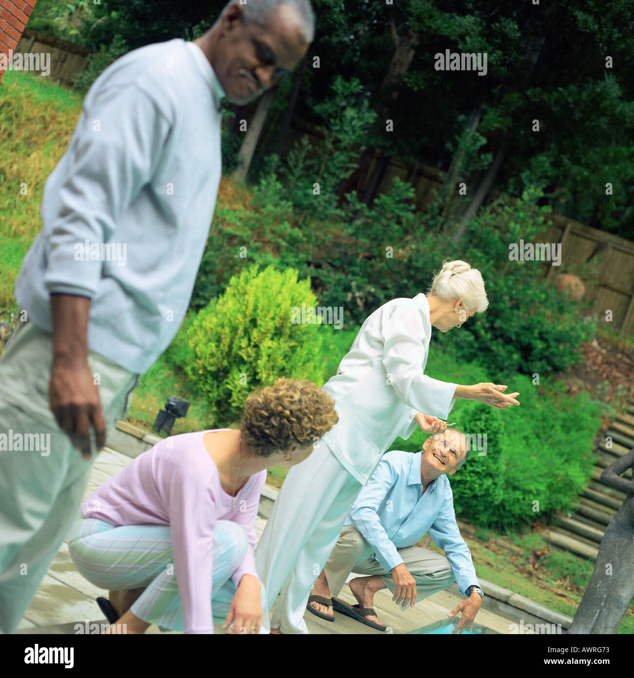 Four people standing in yard Stock Photo - Alamy
