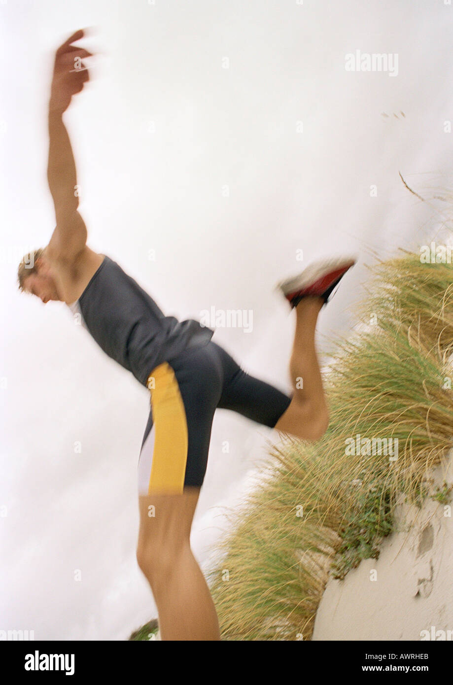 Young man on beach jumping, side view, low angle Stock Photo - Alamy