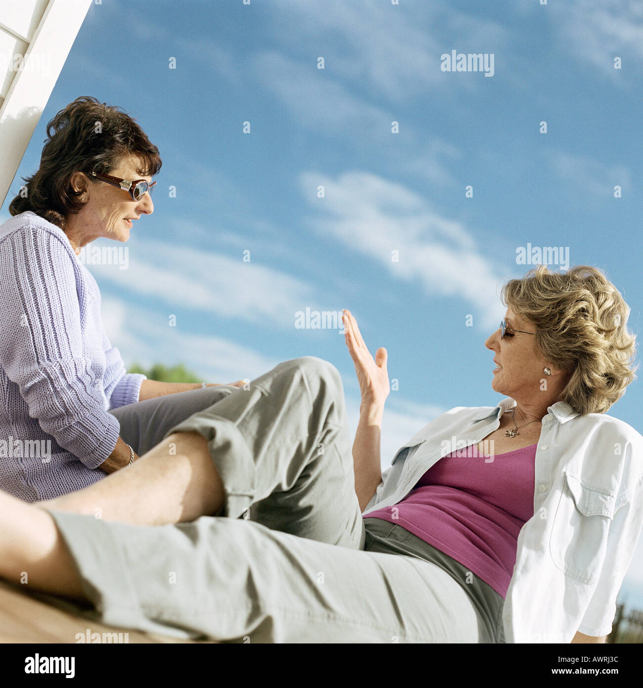 Two mature women talking Stock Photo - Alamy