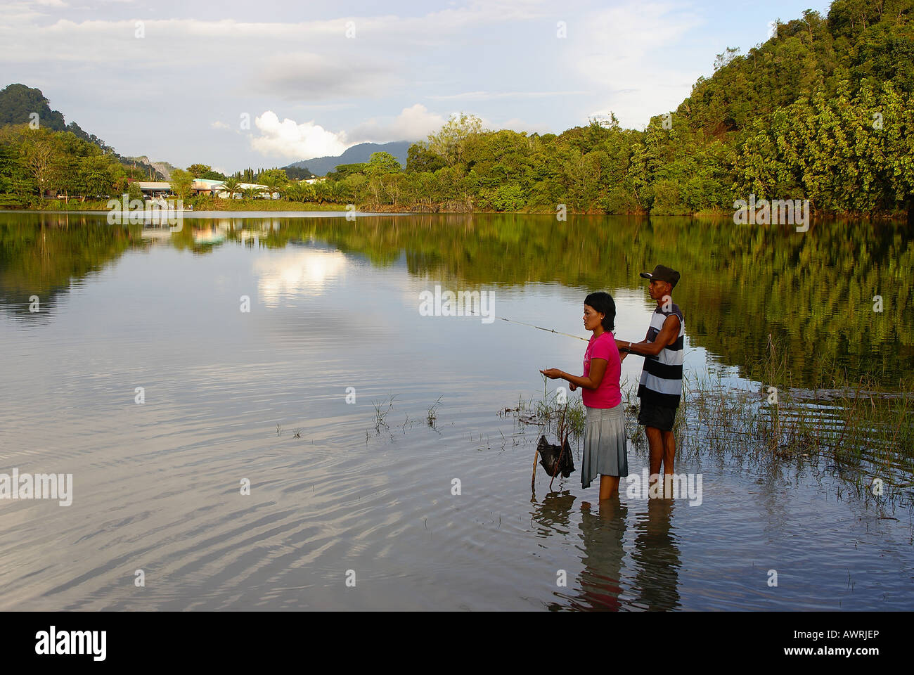 A Bidayuh couple catching catfish at Blue Lake near Bau in Sarawak ...