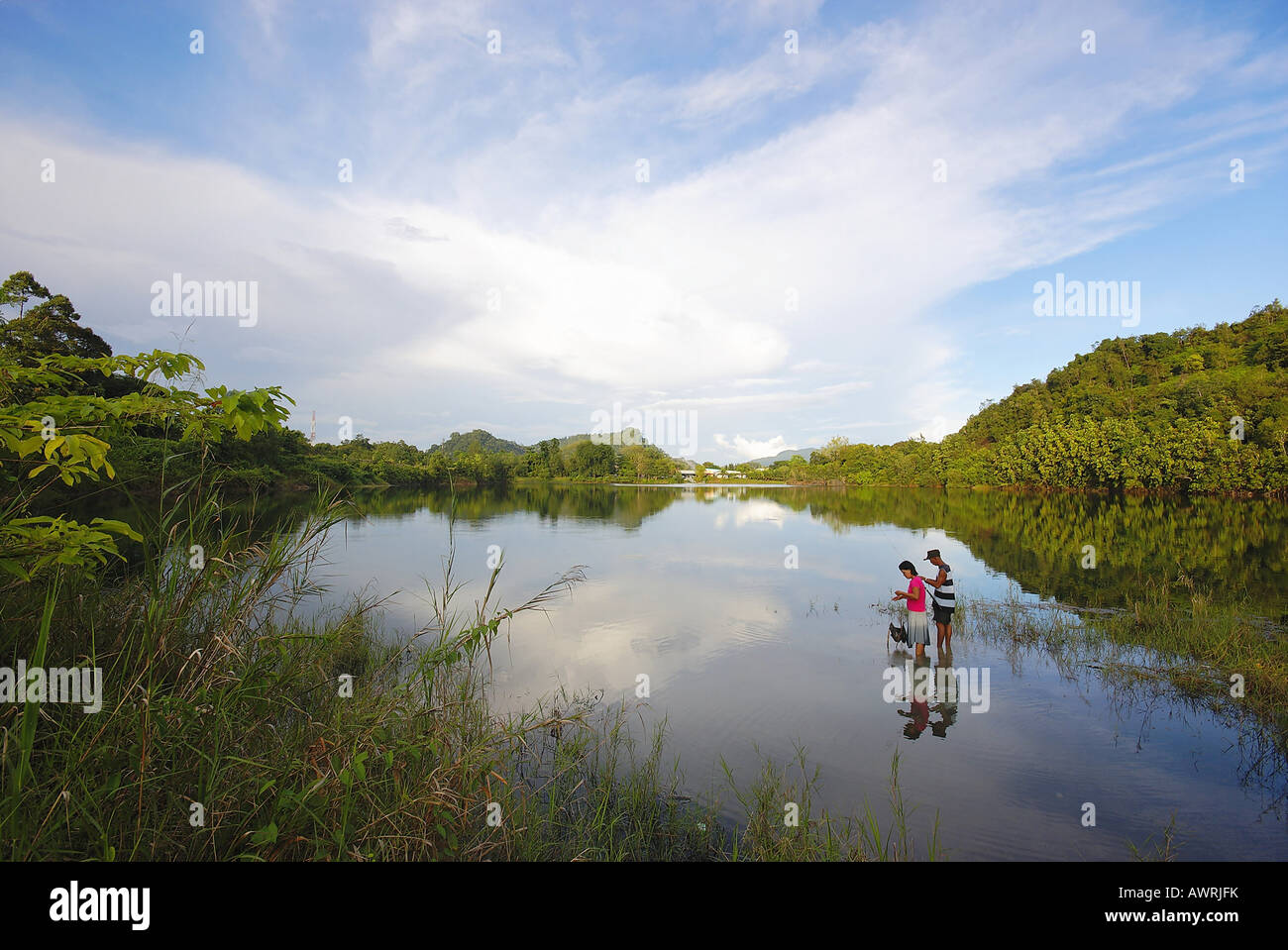 A Bidayuh couple catching catfish at Blue Lake near Bau in Sarawak ...