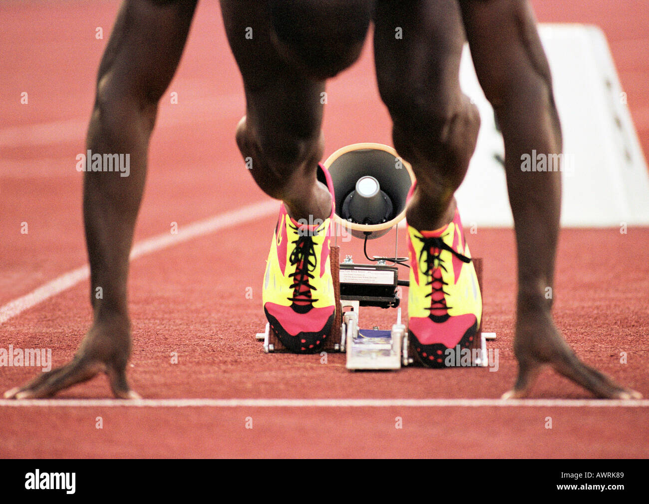 Male runner on starting block, low section, close-up Stock Photo - Alamy
