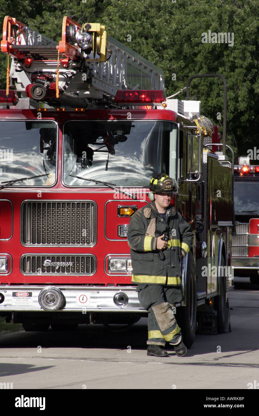 A firefighter by the fire truck listening to the radio at a non ...