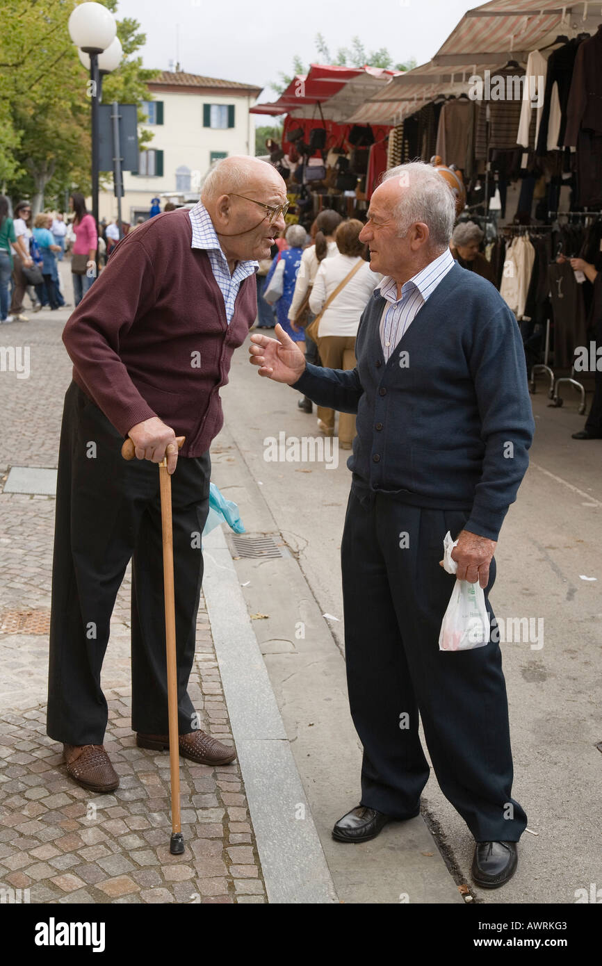 Two old men talking on street at the annual market Camucia Italy Stock ...