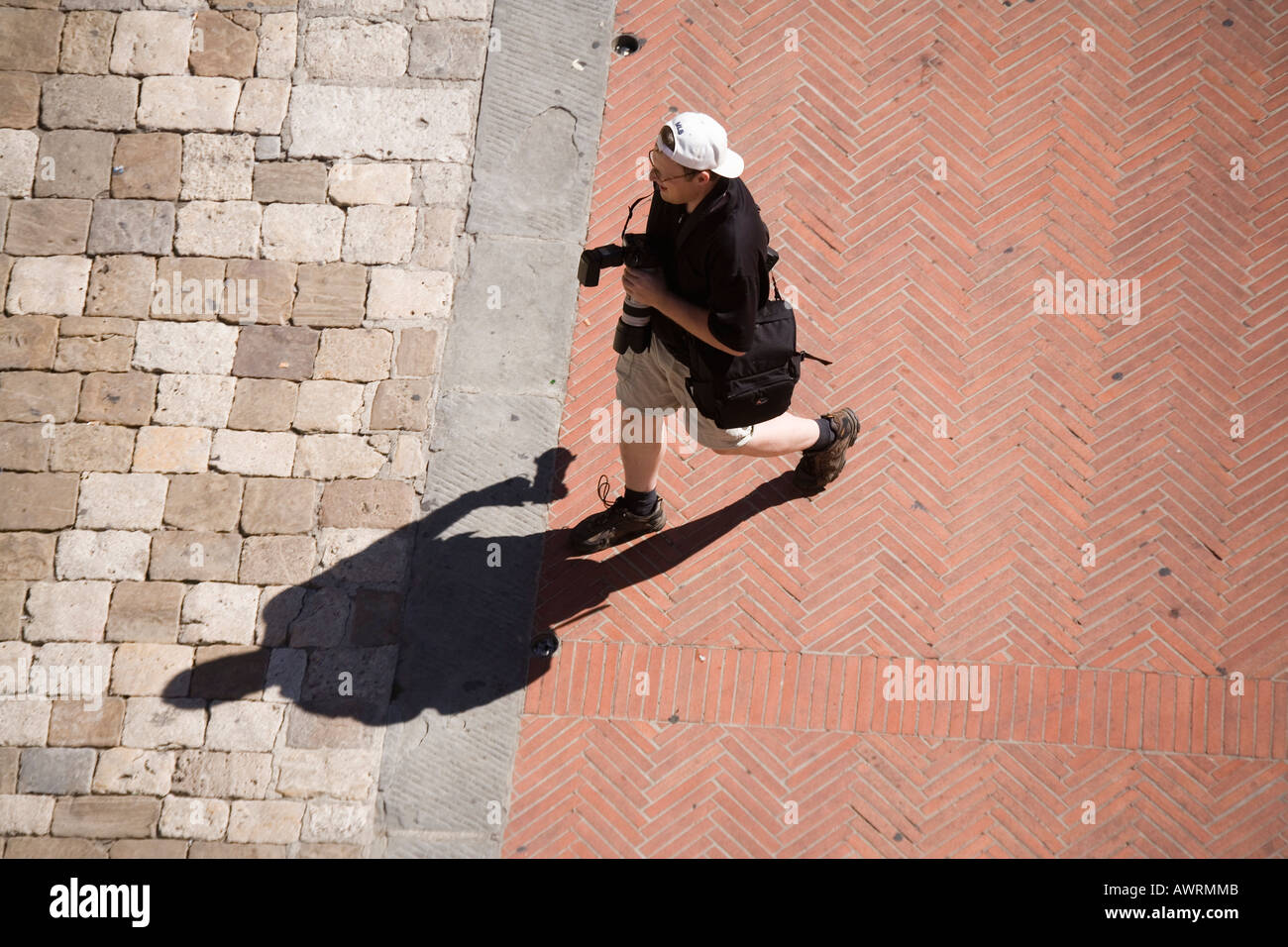 Overhead view of photographer and his shadow walking across Piazza ...
