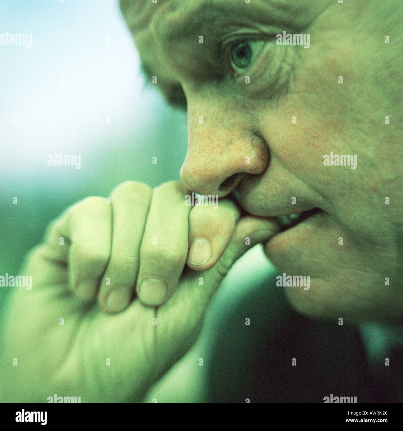 Extreme close-up of man biting thumb, side view, cool tone Stock Photo ...