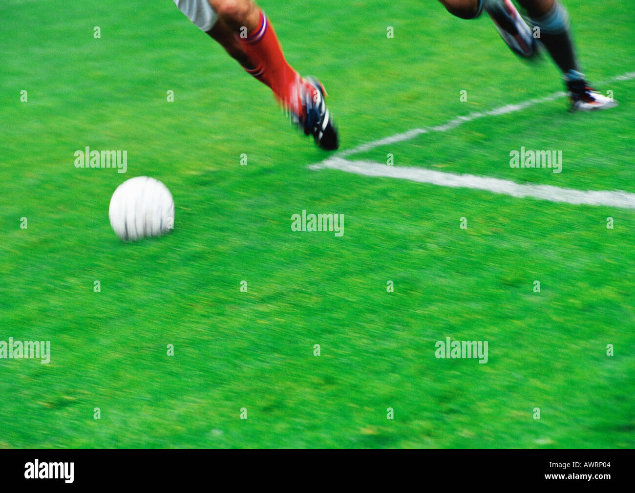 Two soccer players running for ball, blurred, low section Stock Photo ...
