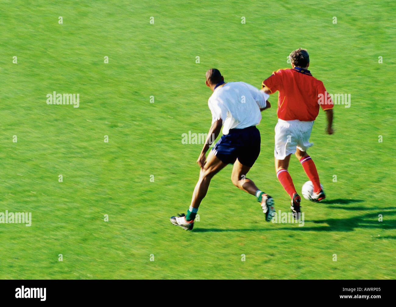Two soccer players running for ball, full length Stock Photo - Alamy