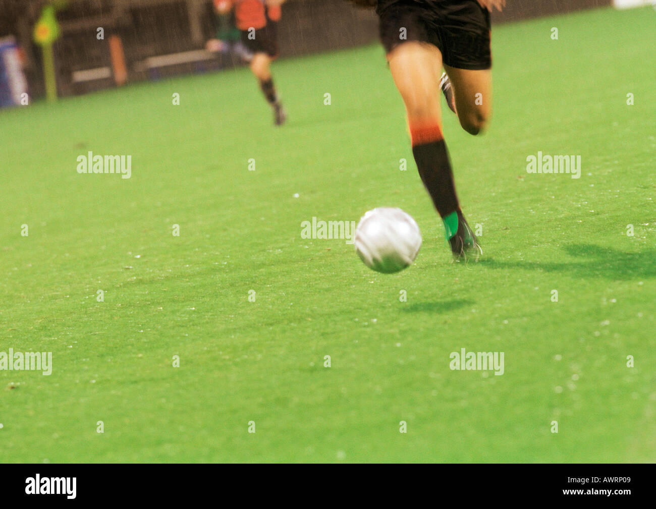 Player running for ball in soccer match, low section Stock Photo - Alamy