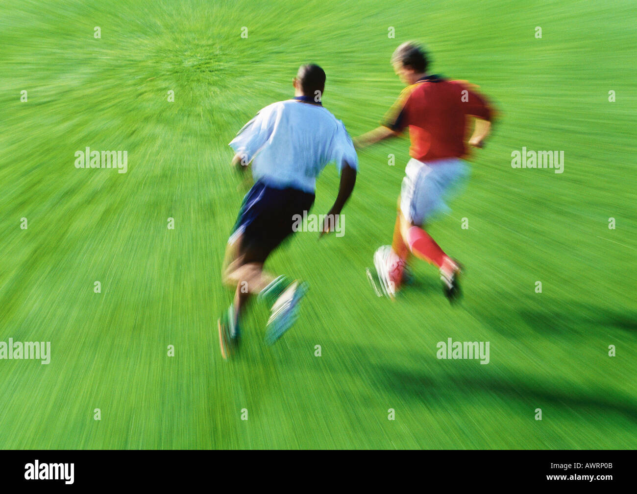 Two soccer players running for ball, blurred Stock Photo - Alamy