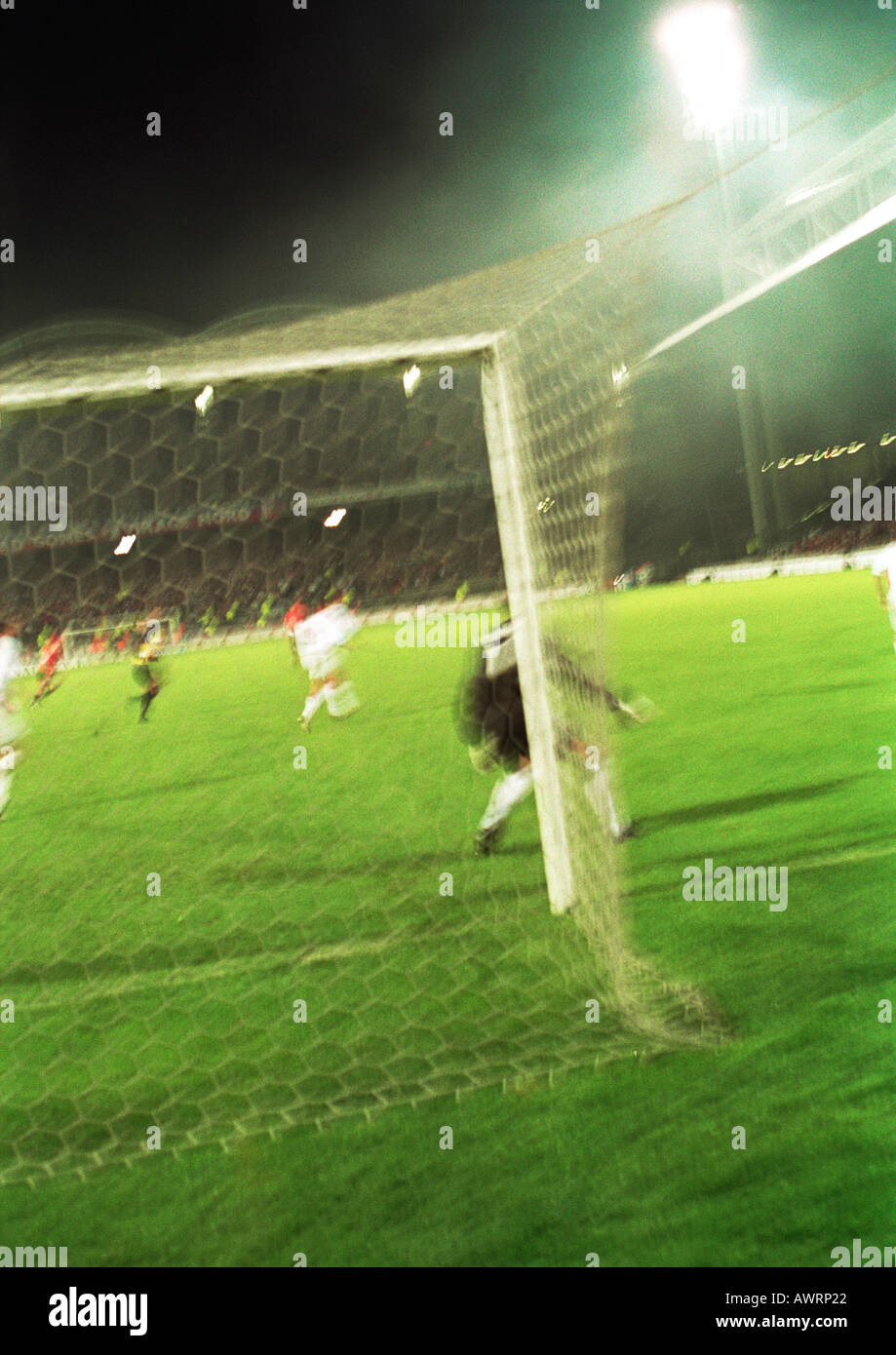 Soccer players during a game, seen from behind the goal, blurred Stock ...