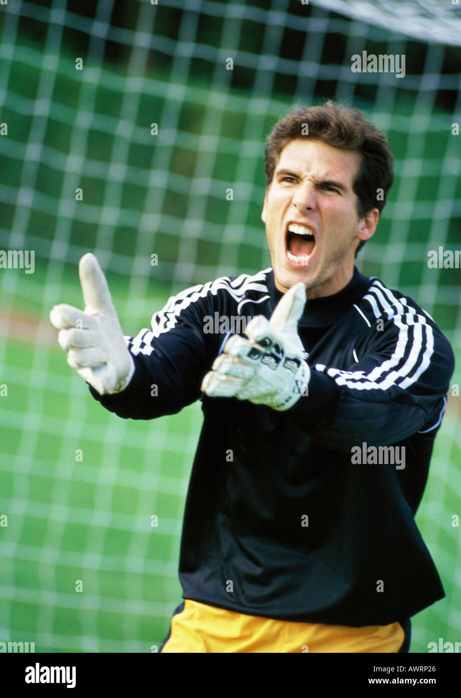 Goal keeper yelling with hands out, portrait Stock Photo - Alamy