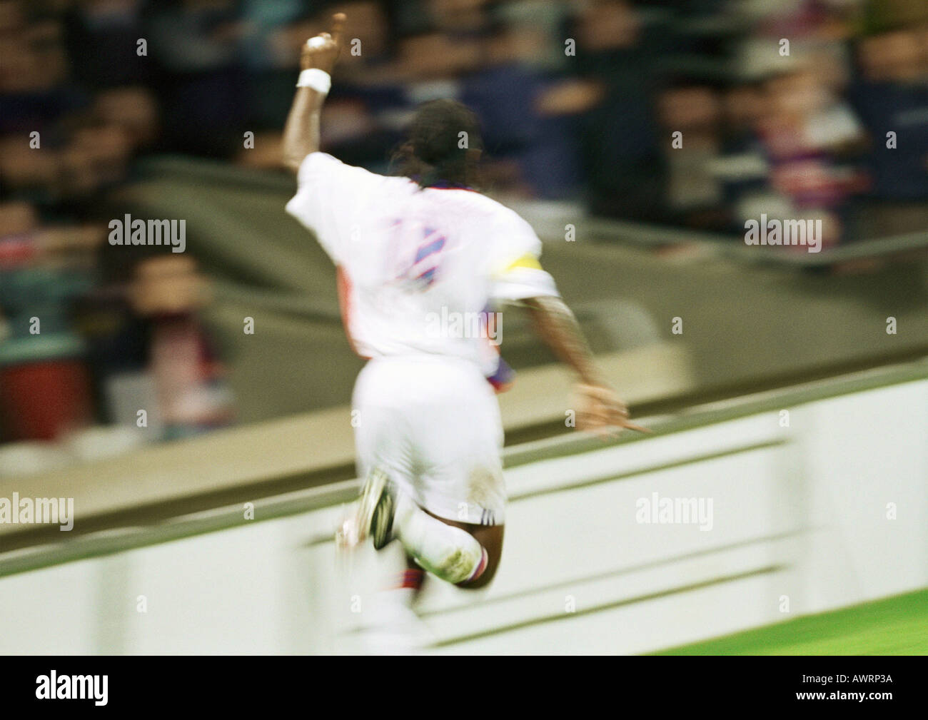 Soccer player running, hand up, rear view Stock Photo - Alamy