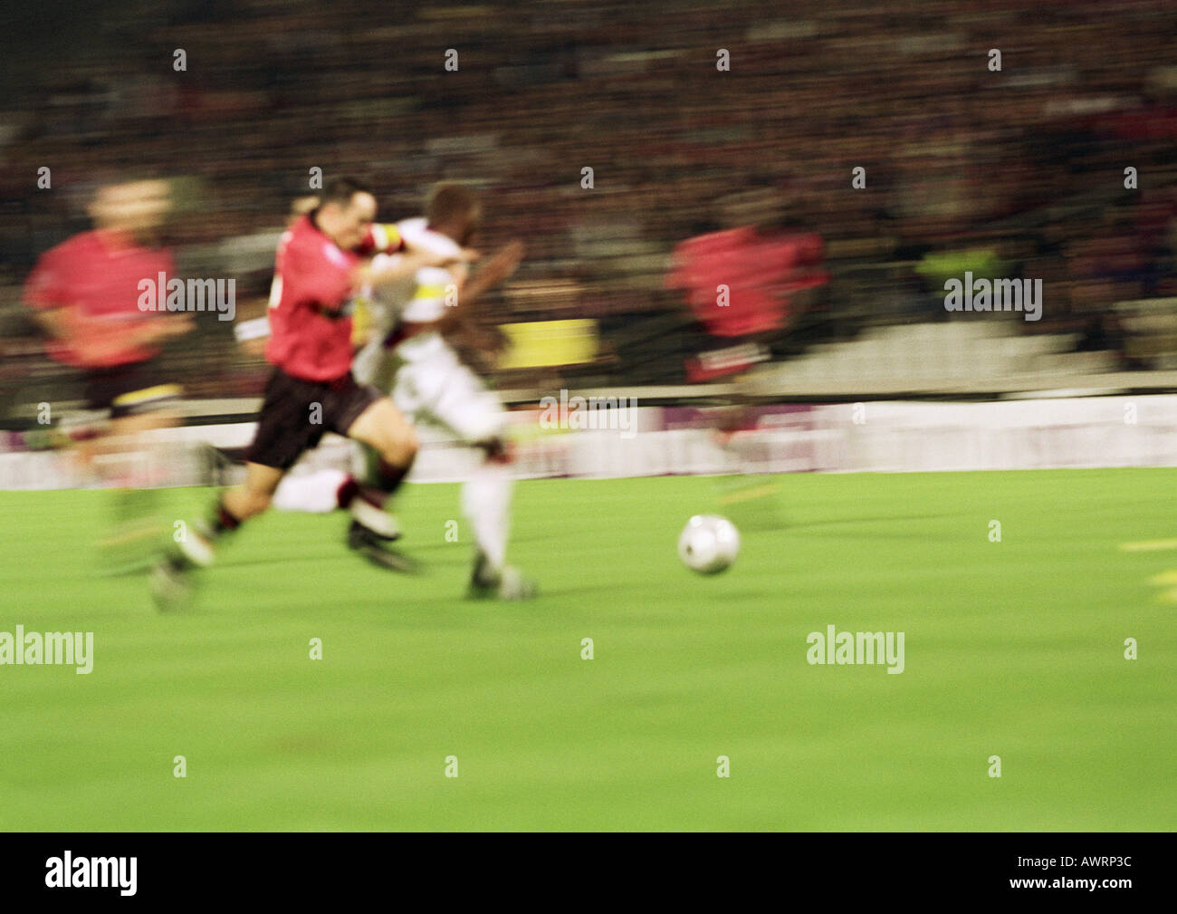 Two soccer players running for ball, blurred Stock Photo - Alamy