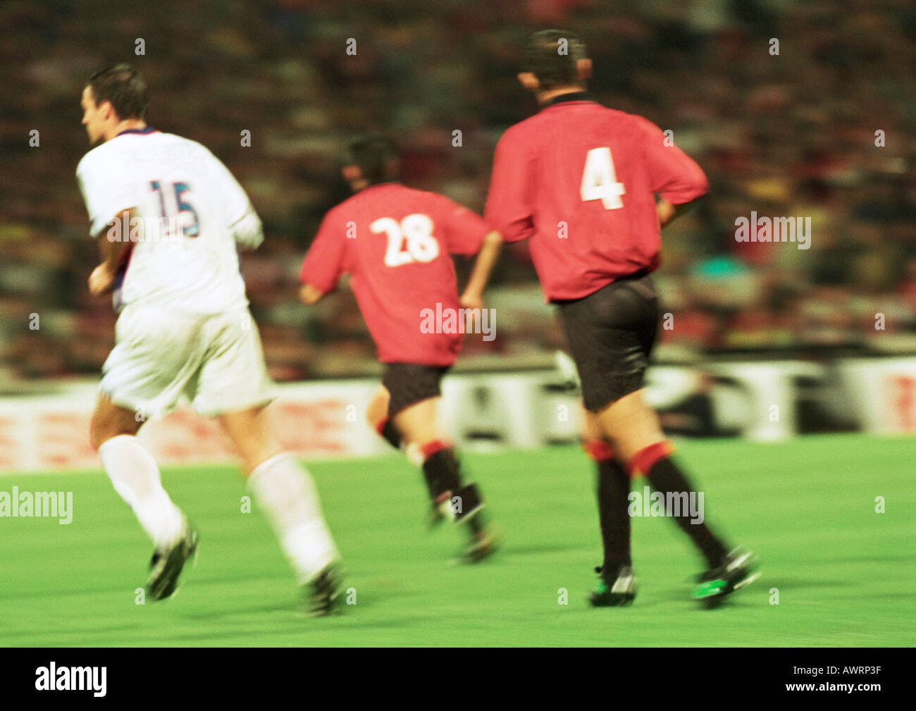 Three soccer players running, rear view, blurred Stock Photo - Alamy