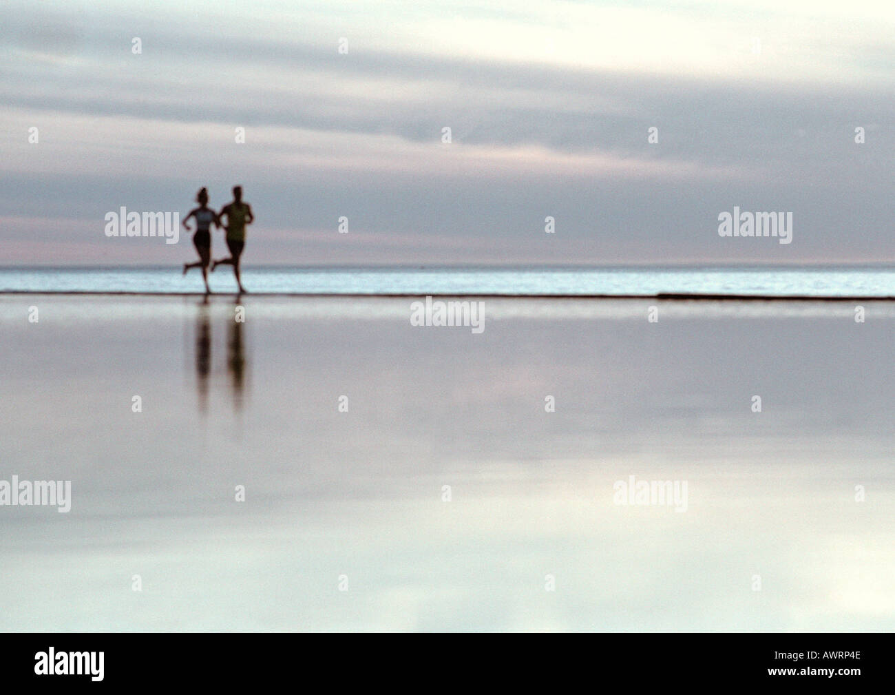 Couple running on beach Stock Photo - Alamy