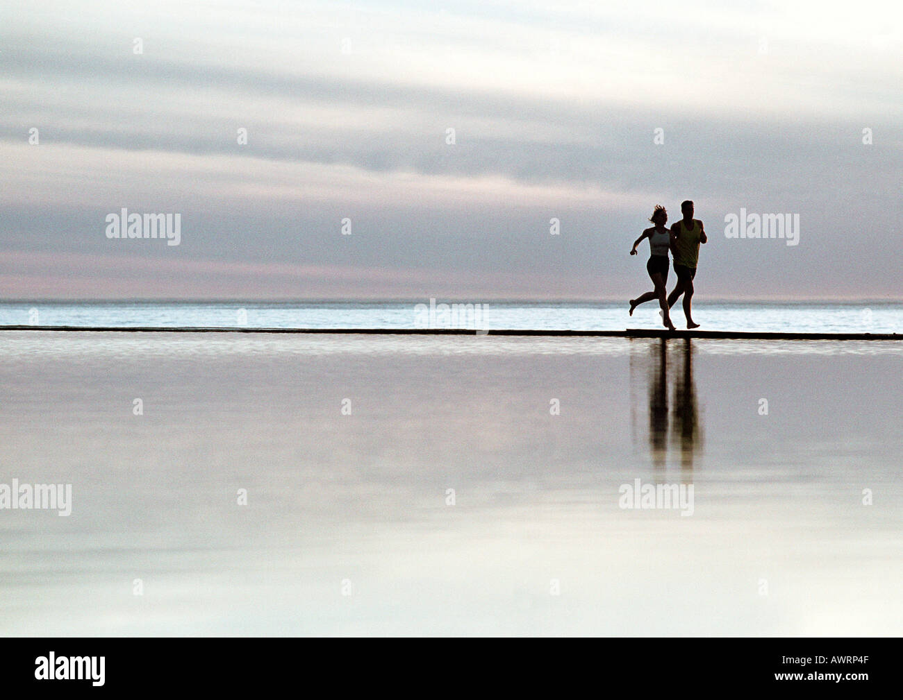 Couple running on beach Stock Photo - Alamy