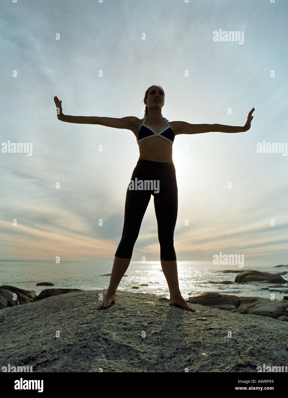 Woman standing on beach, arms extended out, silhouette Stock Photo - Alamy