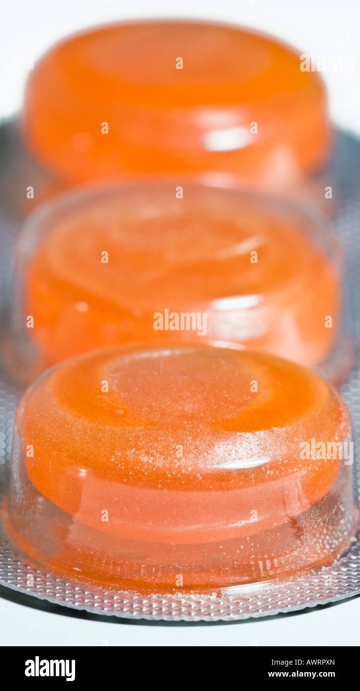A strip of three orange throat lozenges Stock Photo - Alamy