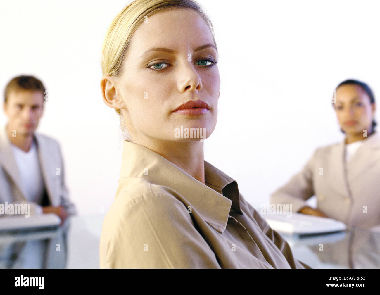Woman looking into camera, colleagues in background, portrait Stock ...