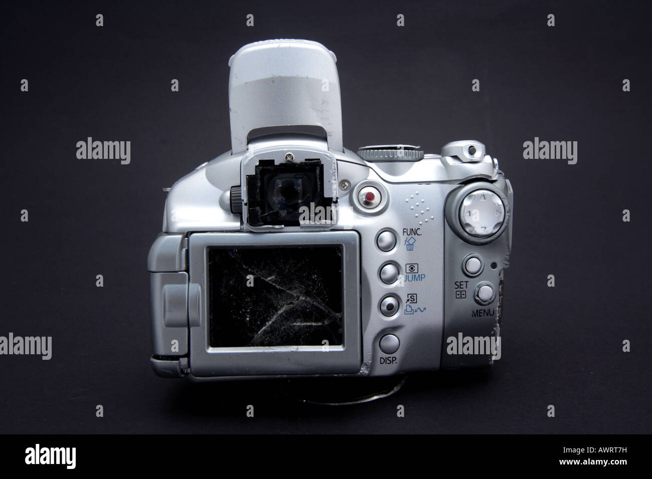 A SEVERLY DAMAGED DIGITAL CAMERA BLACK BACKGROUND BACK VIEW HORIZONTAL ...