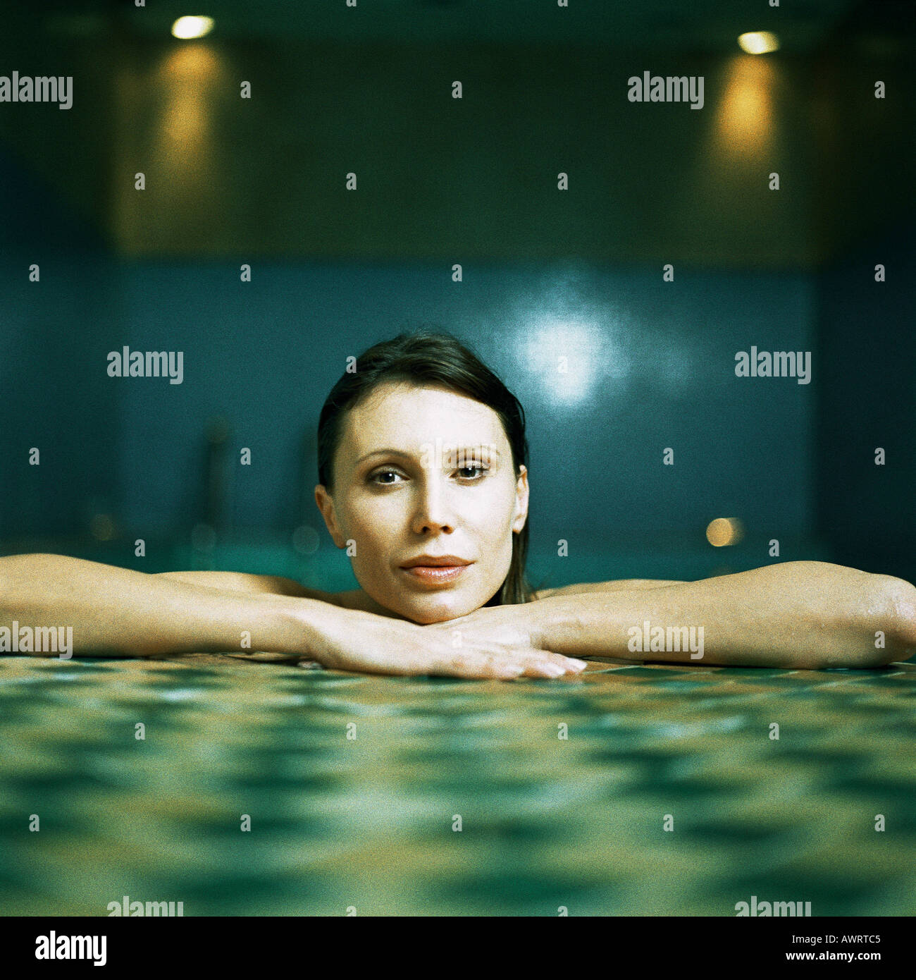 Woman resting arms and head on side of pool, portrait Stock Photo - Alamy