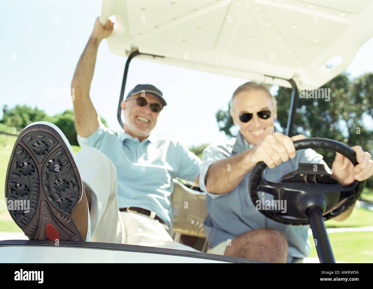 Two mature men in golf cart, smiling, close-up Stock Photo - Alamy