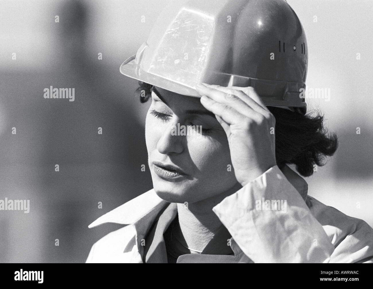 Woman holding hard hat, close-up, b&w Stock Photo - Alamy