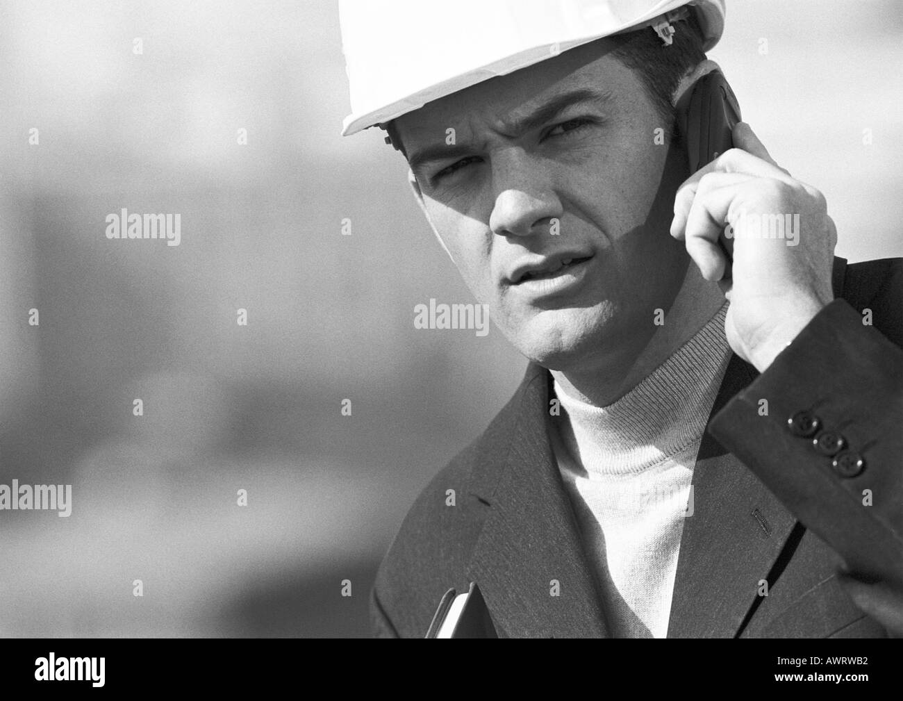 Man with hard hat using cell phone, close-up, b&w Stock Photo - Alamy