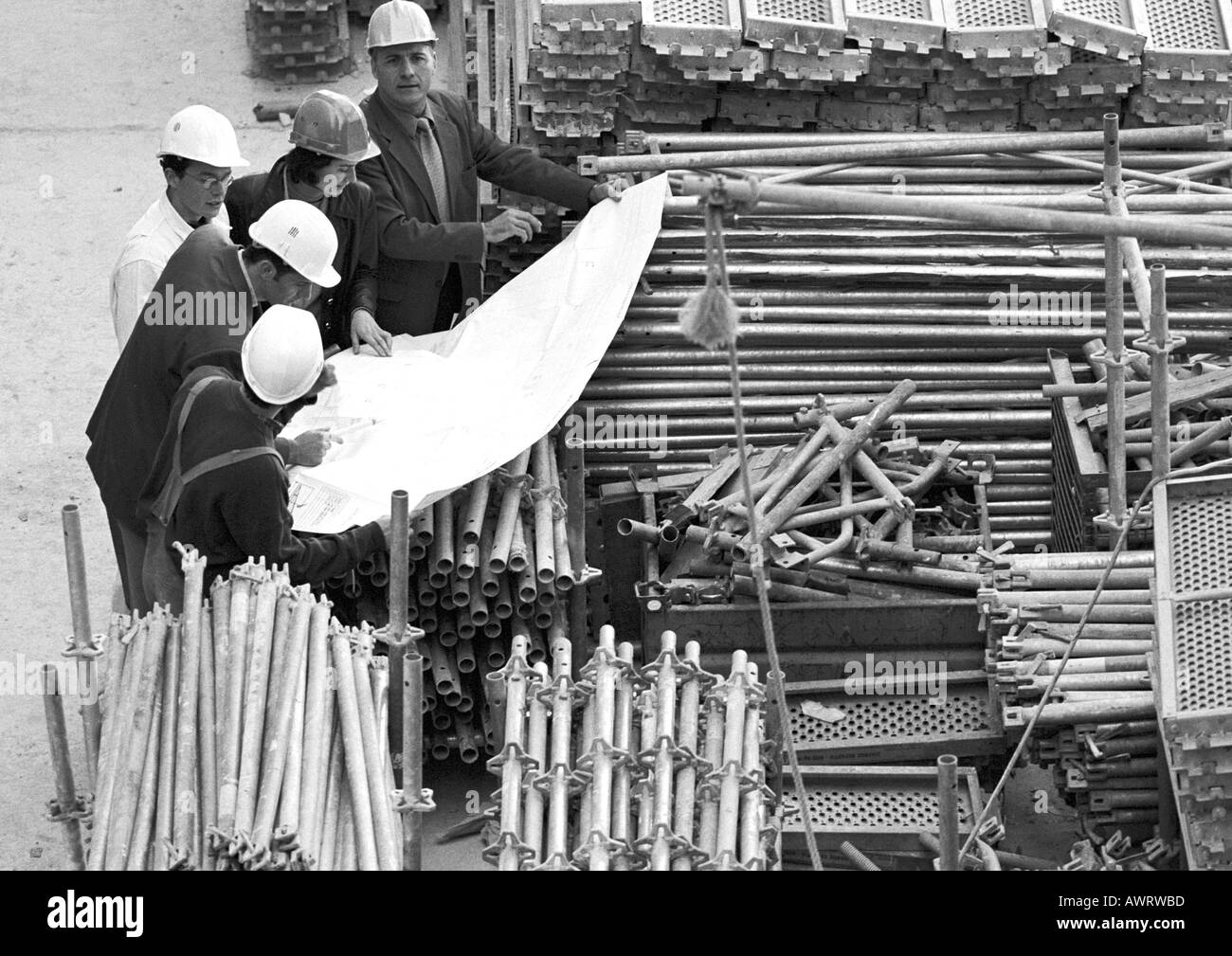 Five people examining blueprints in construction site, b&w Stock Photo ...