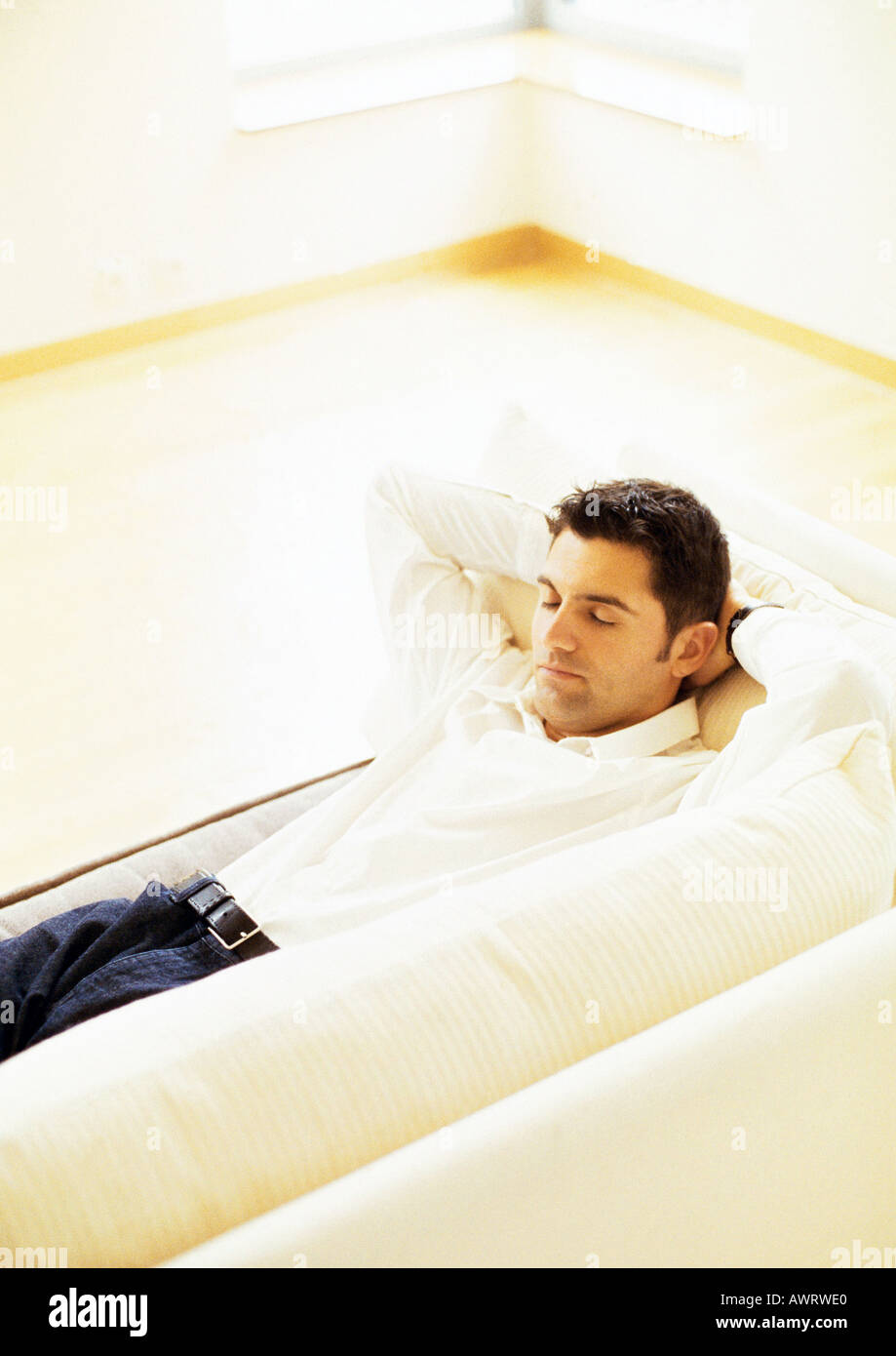 Man lying on sofa Stock Photo - Alamy
