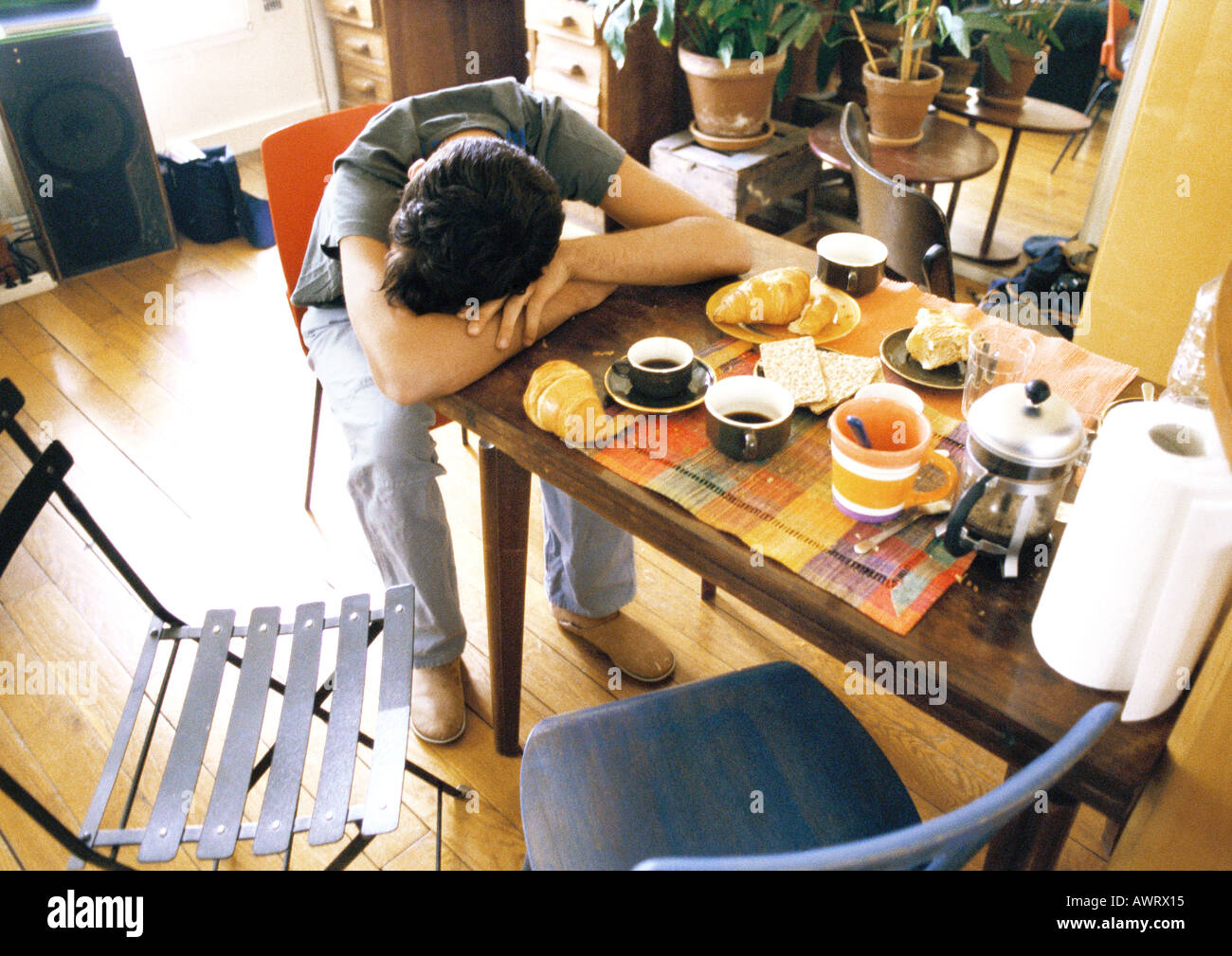 Man resting head on breakfast table Stock Photo - Alamy