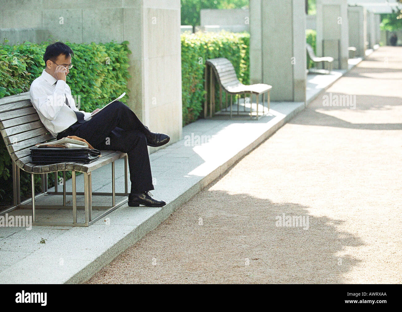 Businessman on bench Stock Photo - Alamy