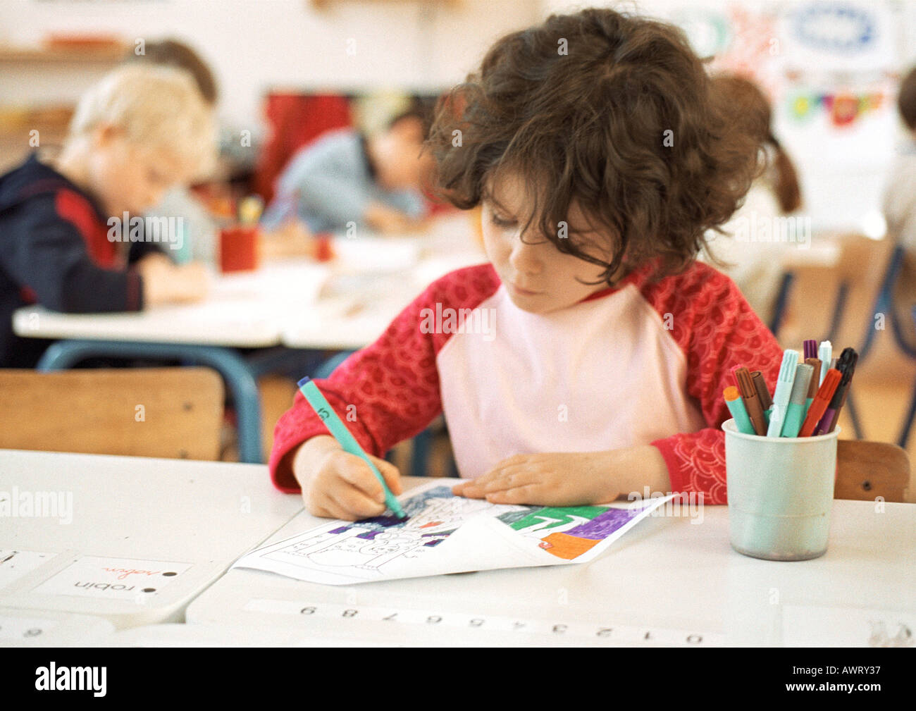 Child sitting at table, drawing, head and shoulders Stock Photo - Alamy