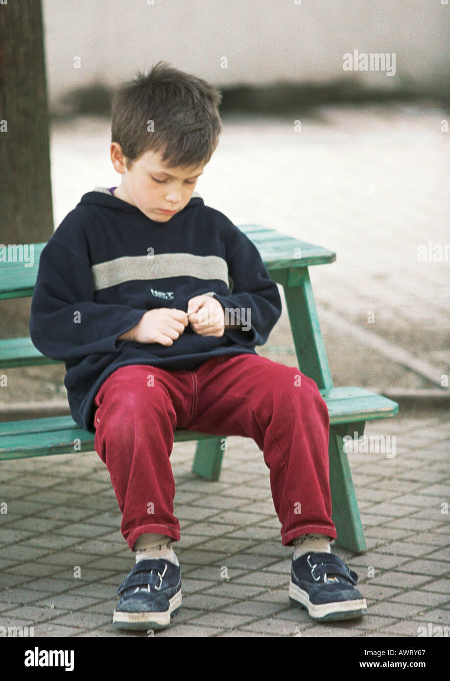 Child sitting on bench Stock Photo - Alamy