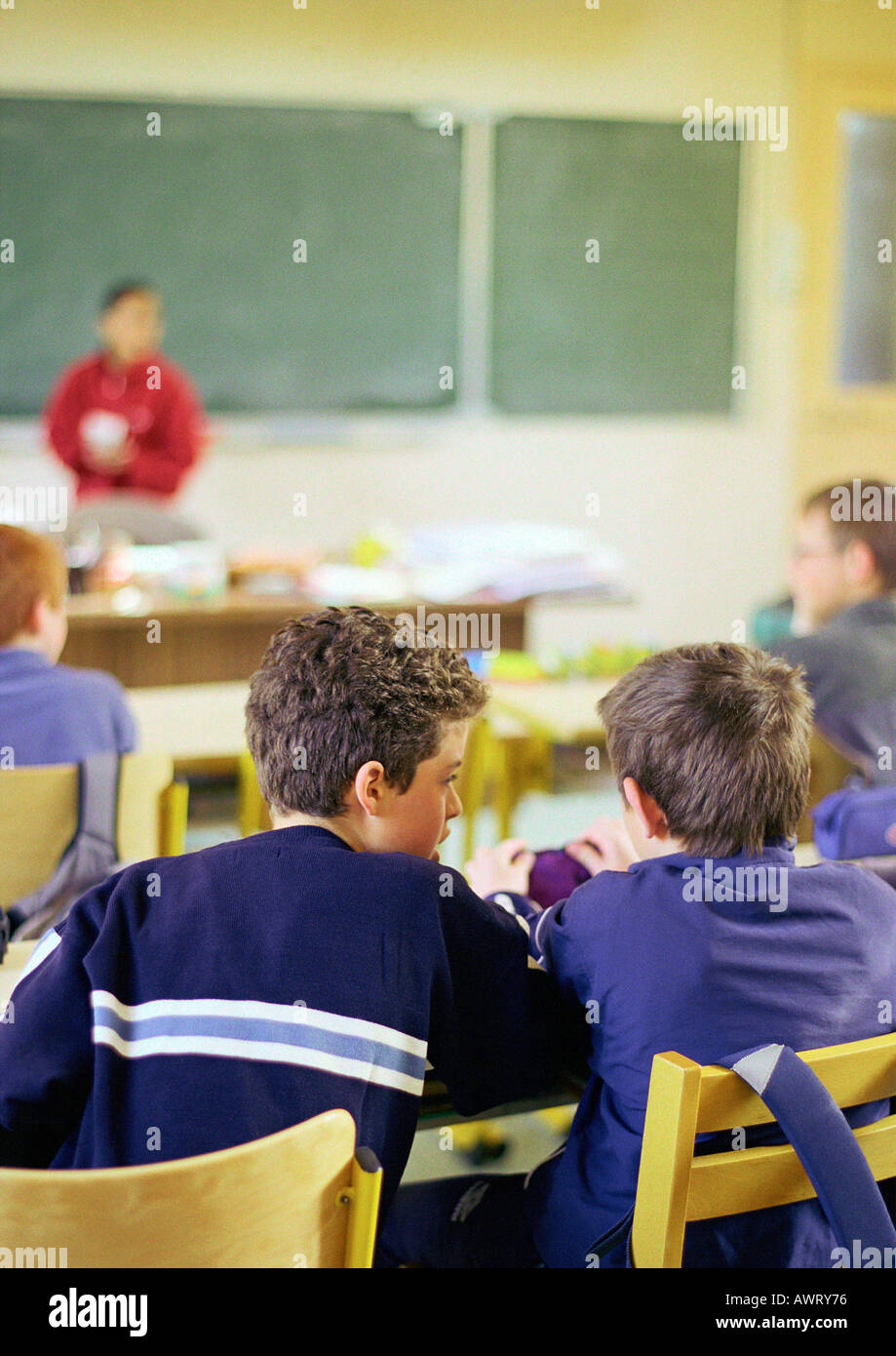 Children in classroom, rear view, chalkboard in background Stock Photo ...